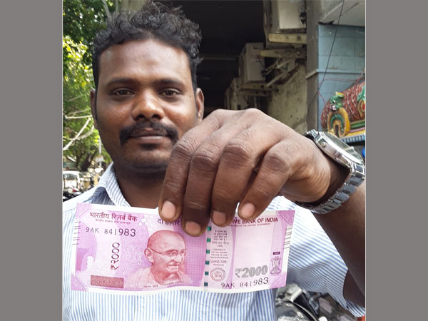 In pics- People pose with the new Rs 2,000 note - Oneindia News